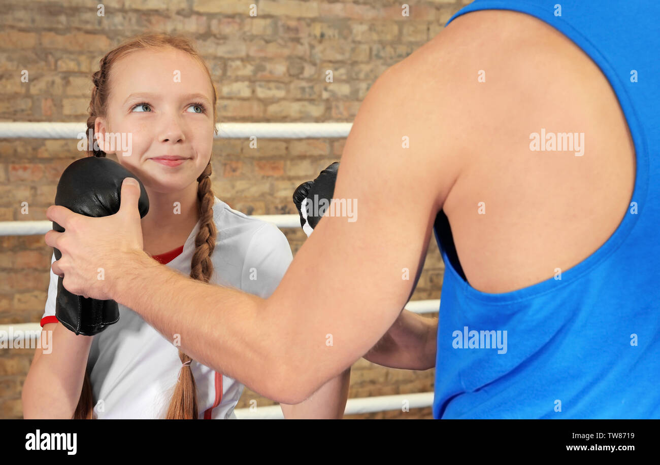 Little girl with trainer on boxing ring Stock Photo - Alamy