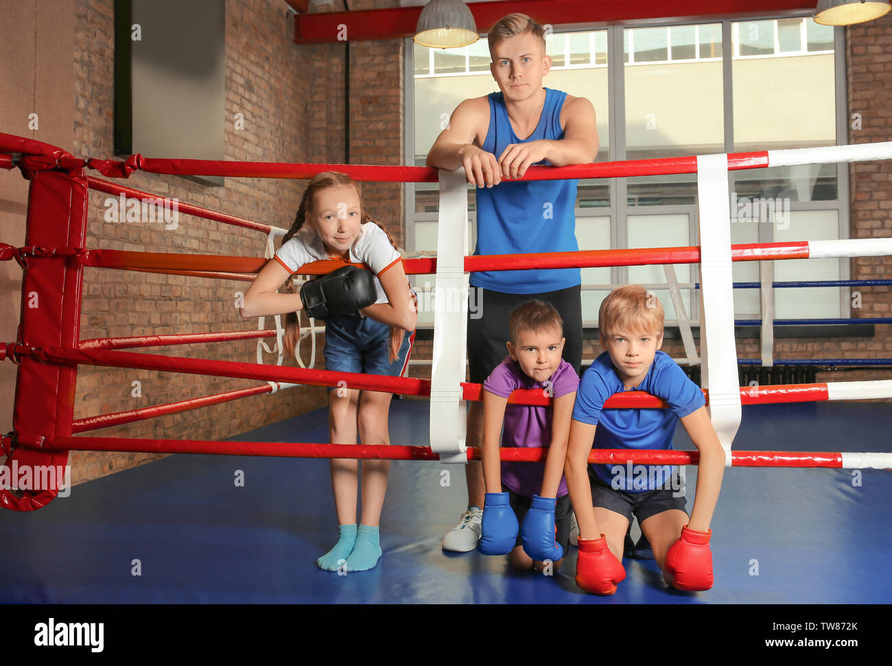 Little children with trainer on boxing ring Stock Photo - Alamy