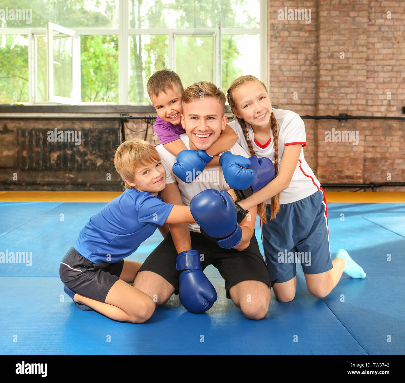 Little children in boxing gloves with trainer indoors Stock Photo - Alamy