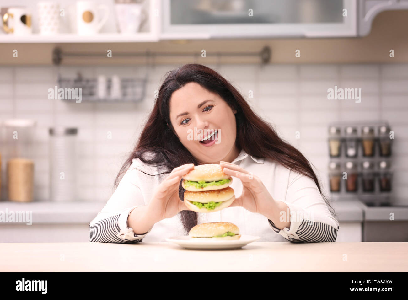 Woman overeating table hi-res stock photography and images - Alamy
