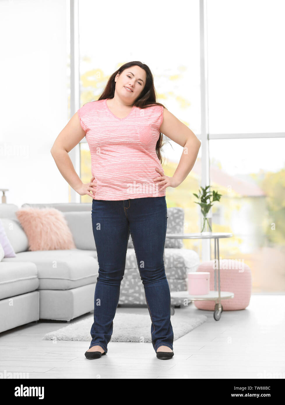 Overweight young woman posing at home Stock Photo - Alamy
