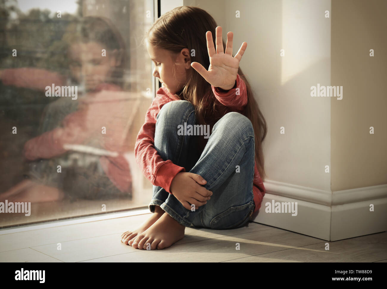 Helpless little girl near window. Abuse of children concept Stock Photo ...