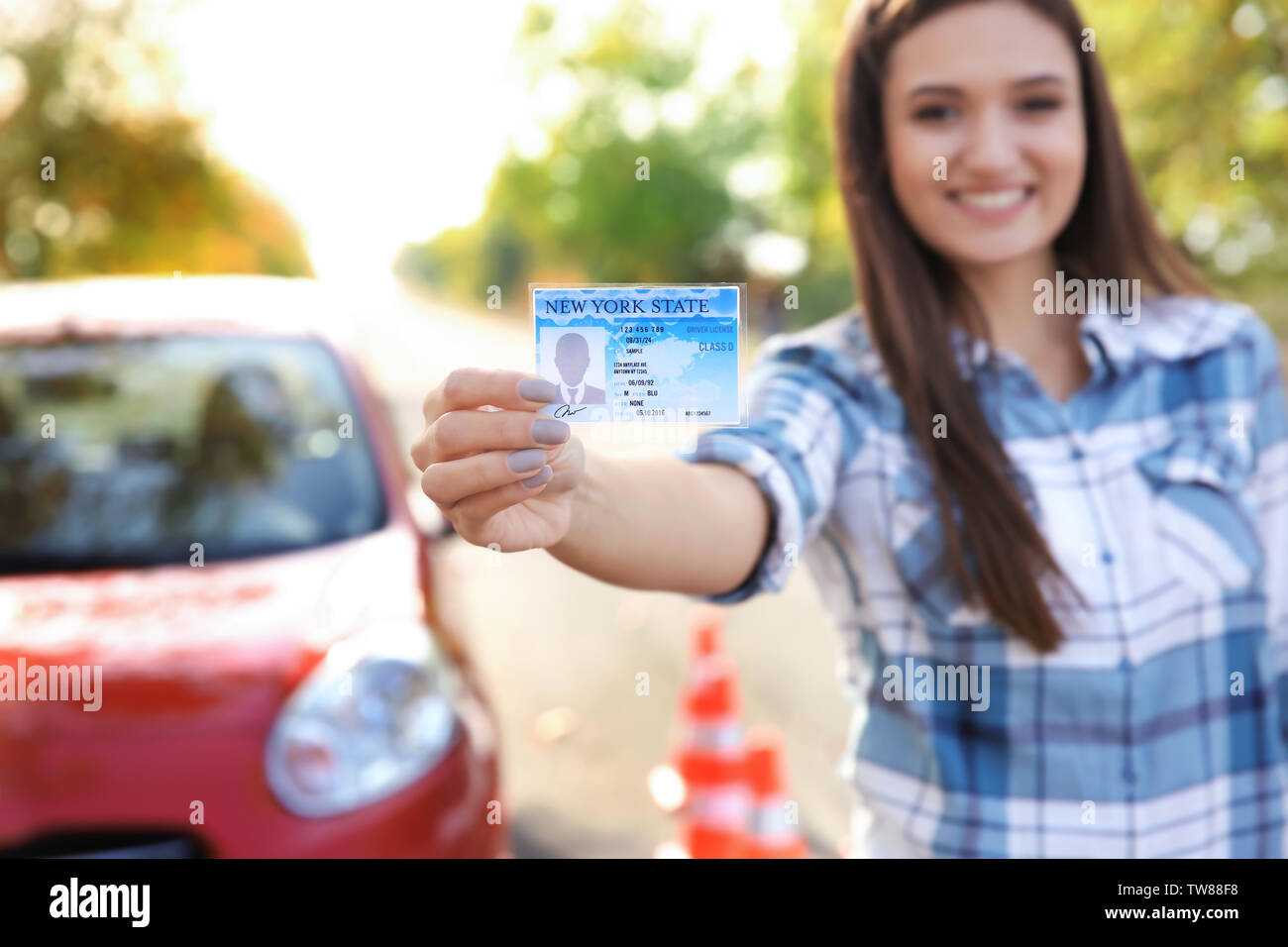Young happy woman holding driving license near car Stock Photo - Alamy