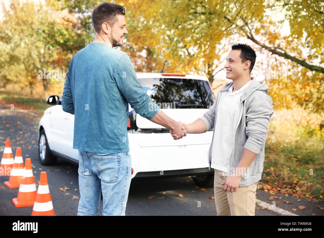 Instructor and young man passed driving license exam, outdoors Stock ...
