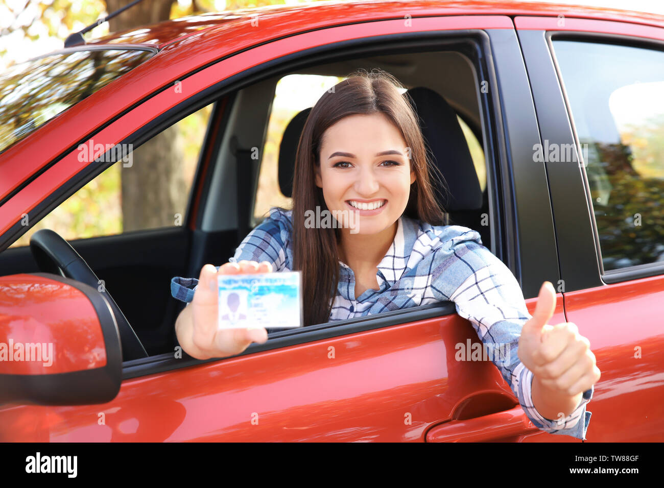 Young happy woman holding driving license in car Stock Photo - Alamy