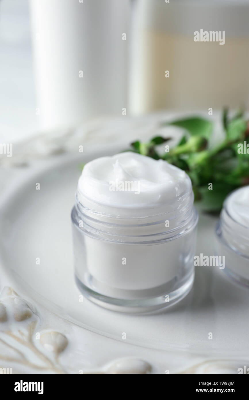Jar of body cream on plate Stock Photo - Alamy