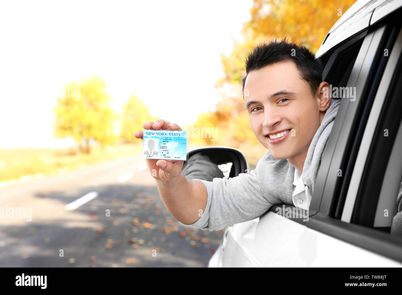 Young man holding driving license in car Stock Photo - Alamy