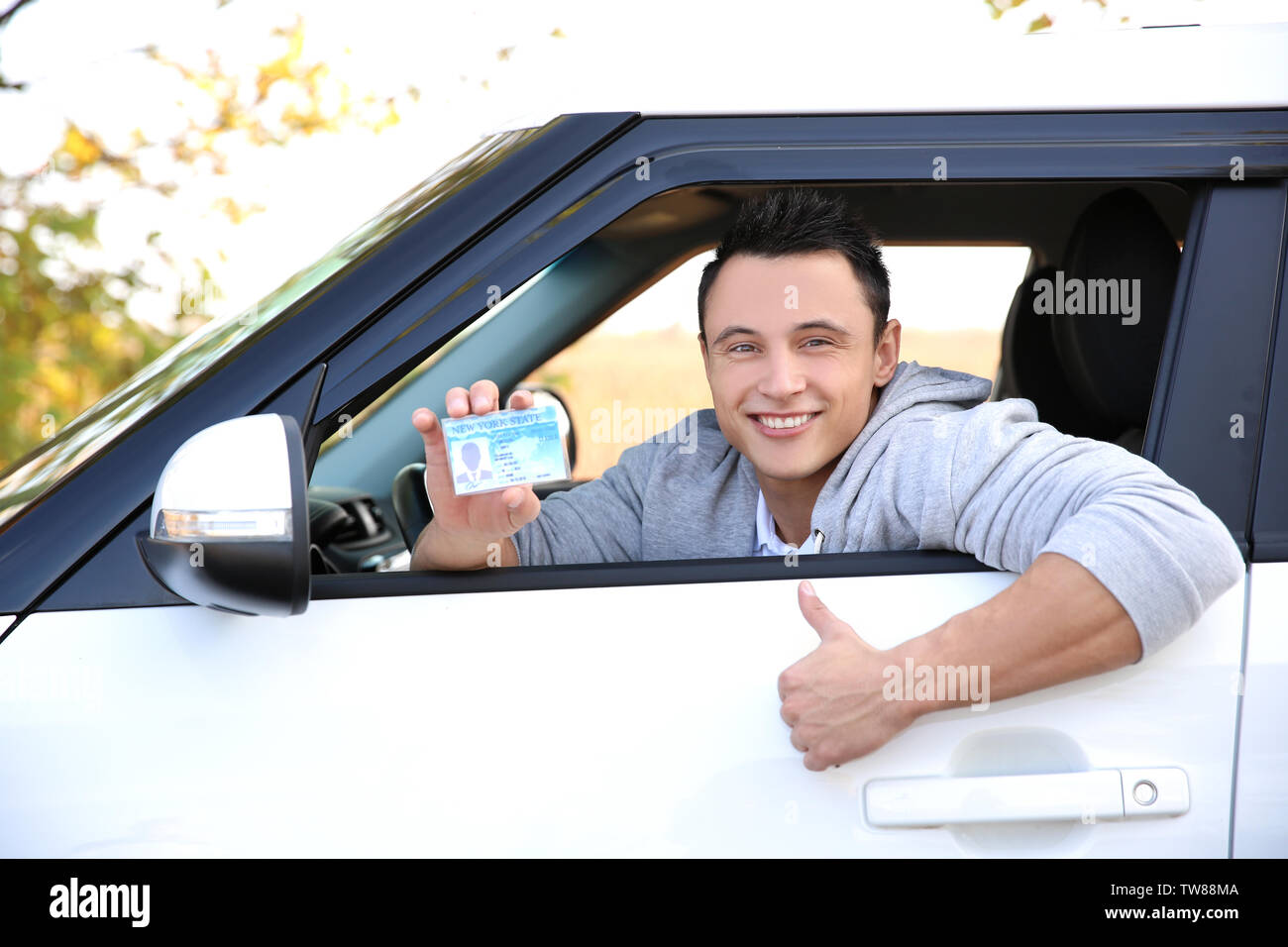 Young man holding driving license in car Stock Photo - Alamy