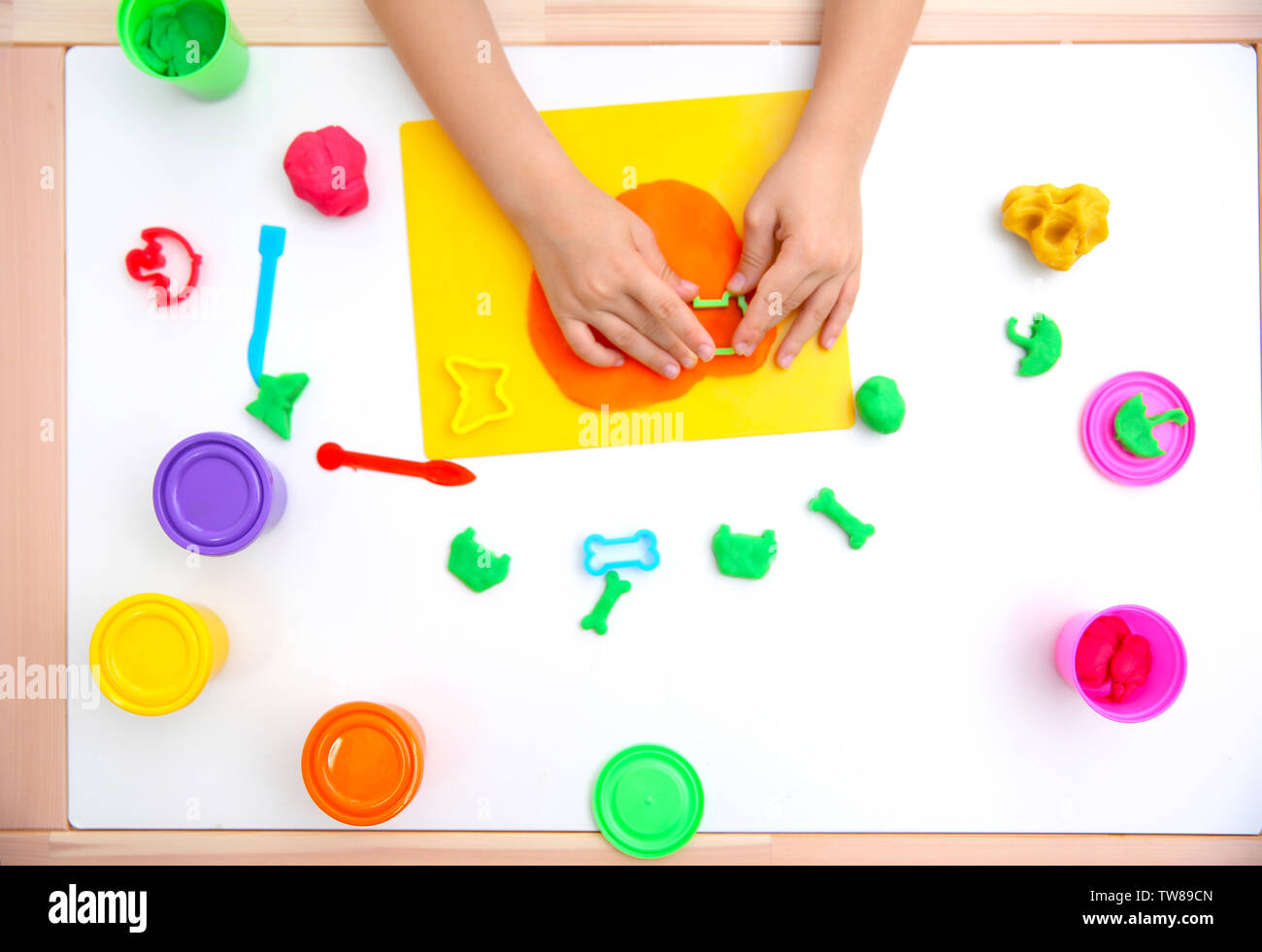 Little child engaged in playdough modeling at table, top view Stock ...