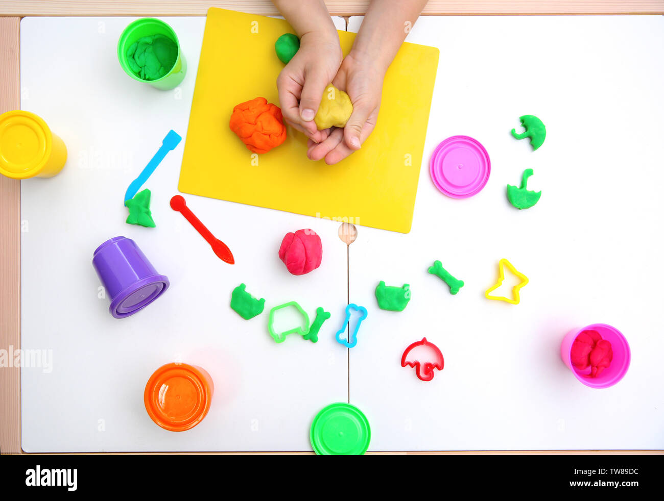 Little child engaged in playdough modeling at table, top view Stock ...