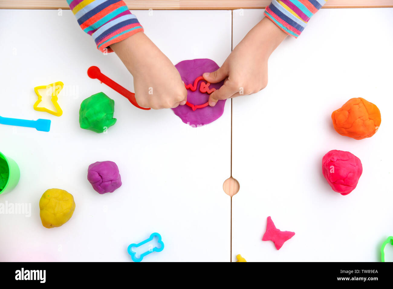 Little girl engaged in playdough modeling at table, top view Stock ...