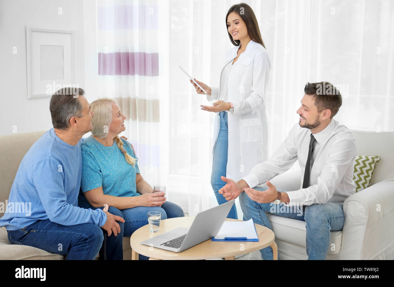 Female doctor with clients at insurance agency Stock Photo - Alamy