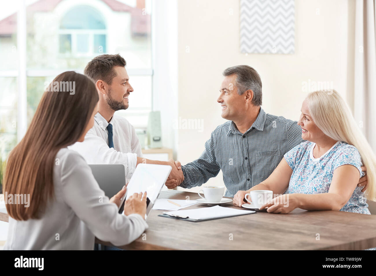 Insurance agents consulting senior couple in office Stock Photo - Alamy