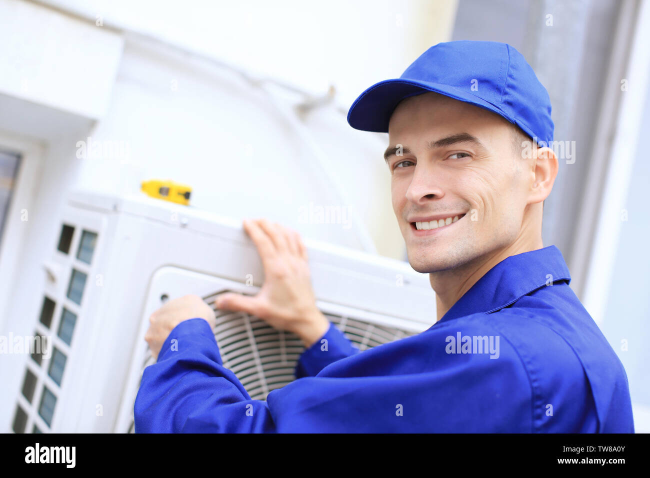 Male technician repairing conditioner outdoors Stock Photo - Alamy