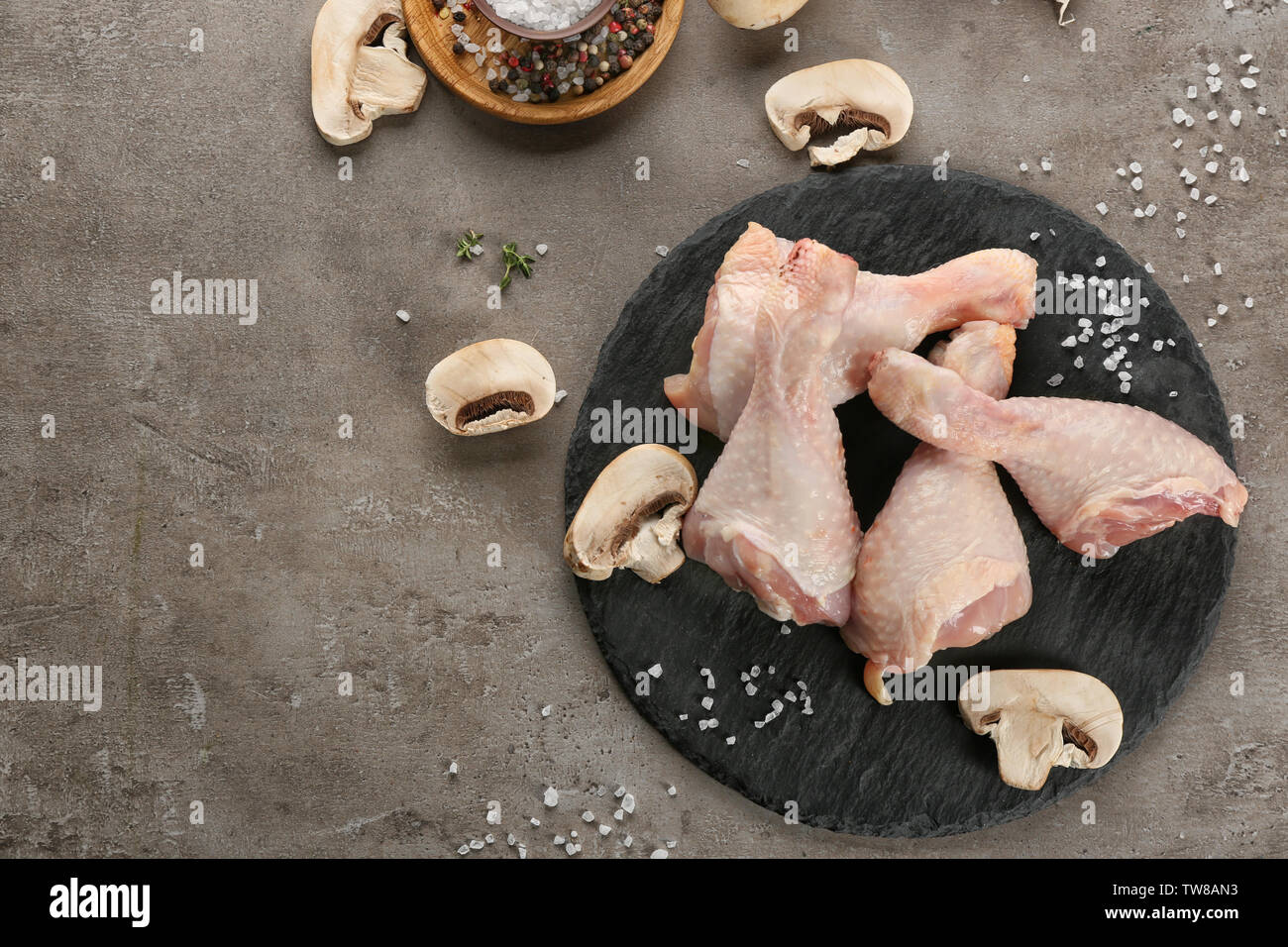 Slate plate with raw chicken legs on grey background, top view Stock ...
