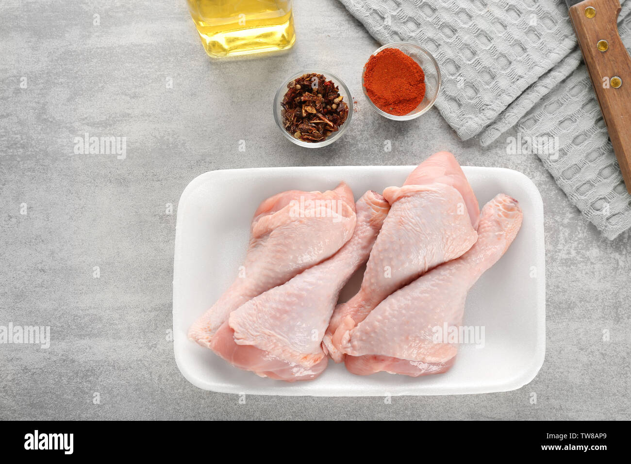 Container with raw chicken legs on table, top view Stock Photo - Alamy