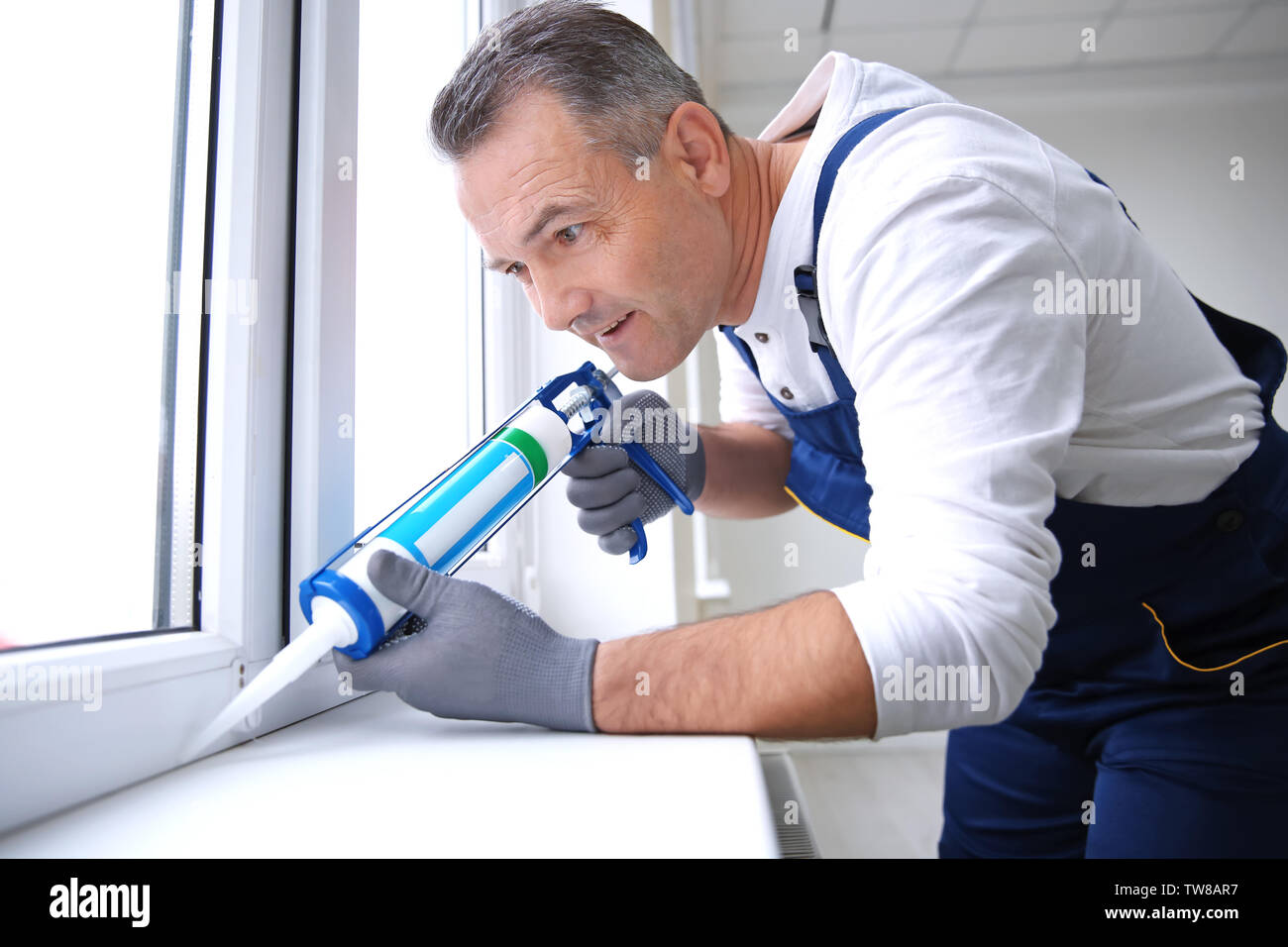 Construction worker installing window in house Stock Photo - Alamy