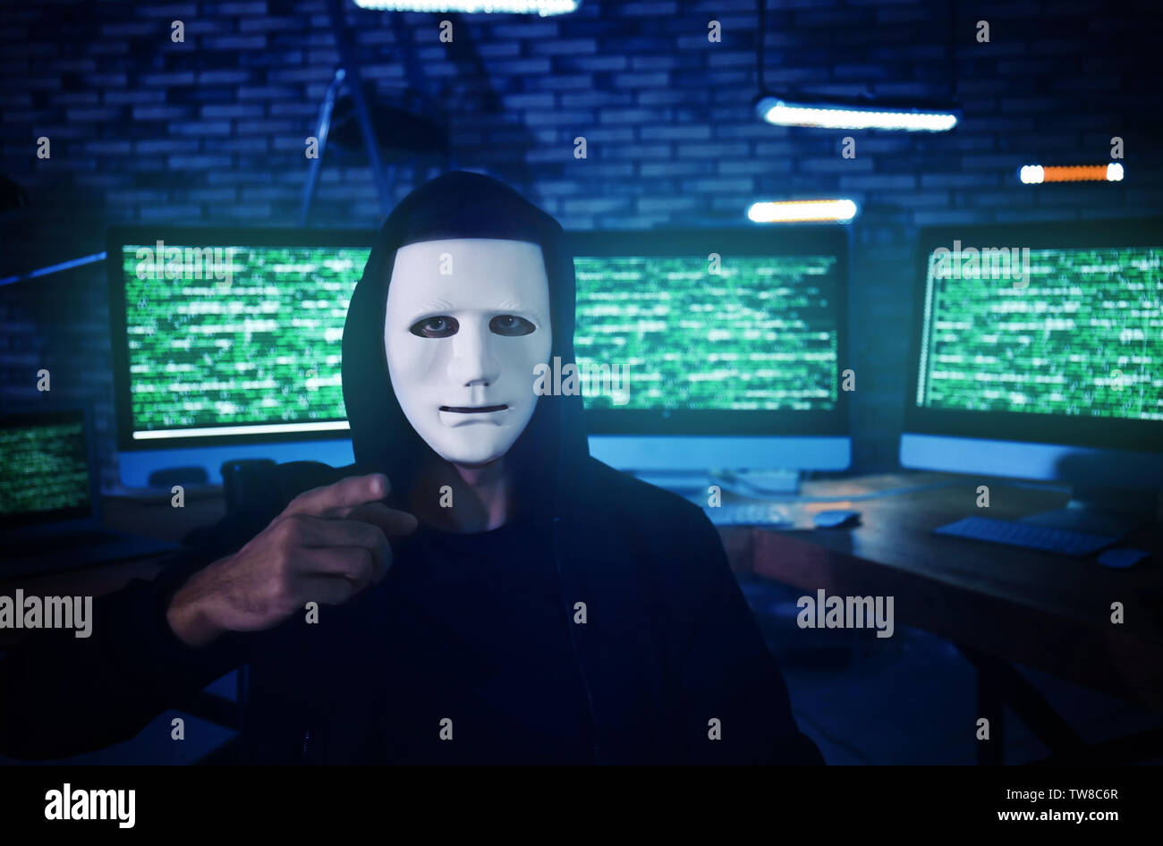 Masked hacker in dark room with computers. Threat of cyber attack Stock ...