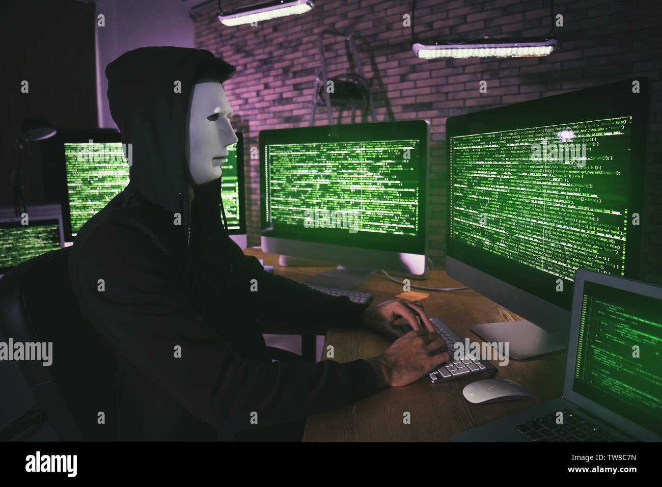 Masked hacker using computer in dark room. Threat of cyber attack Stock Photo - Alamy