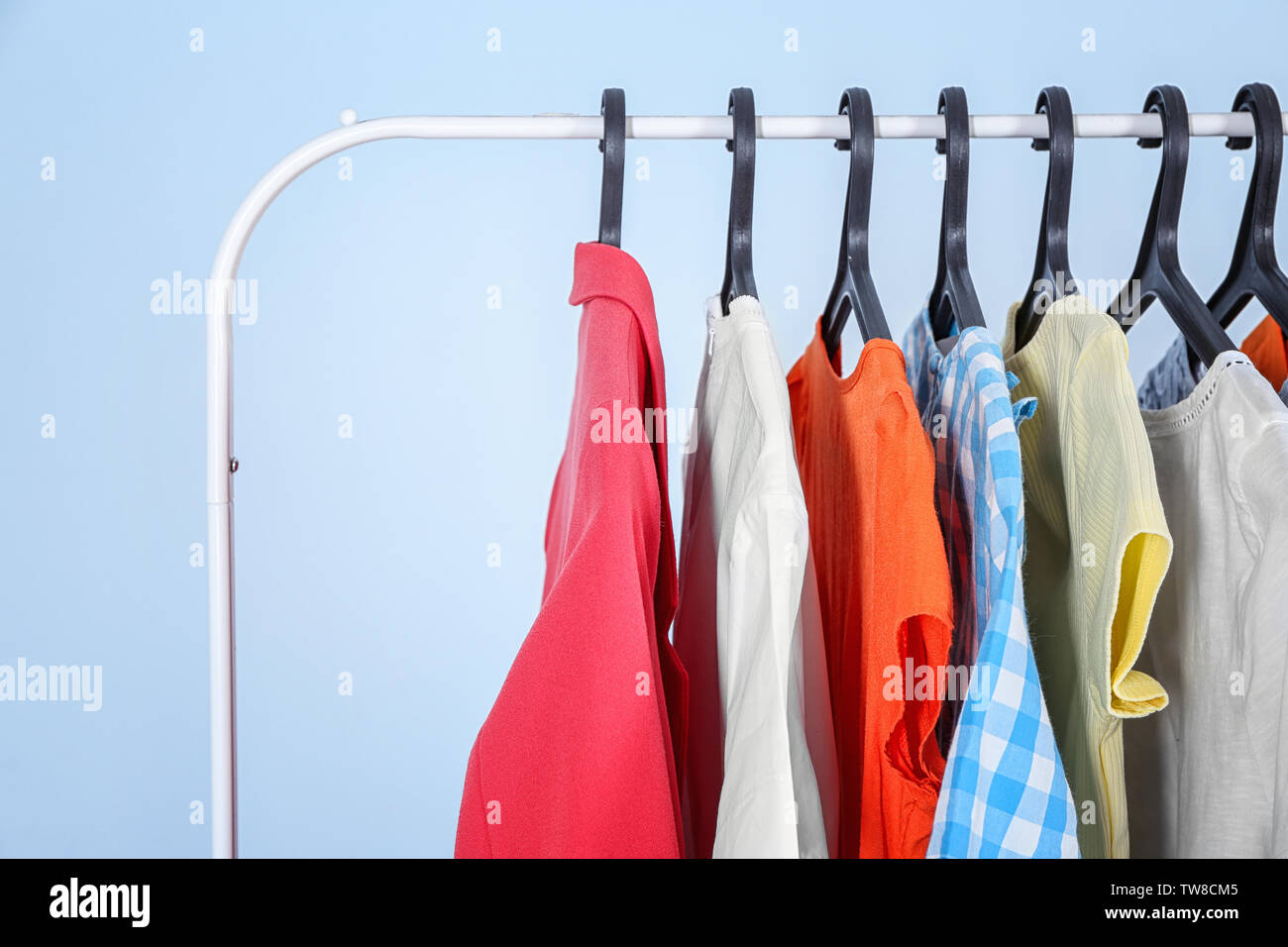 Clean clothes hanging on rack in laundry Stock Photo - Alamy