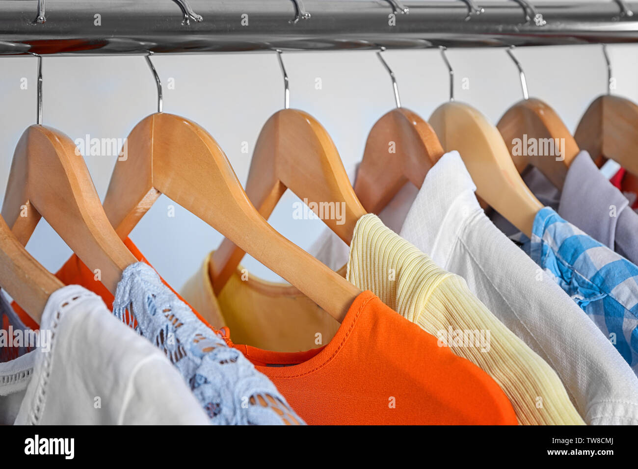 Clean clothes hanging on rack in laundry, closeup Stock Photo - Alamy