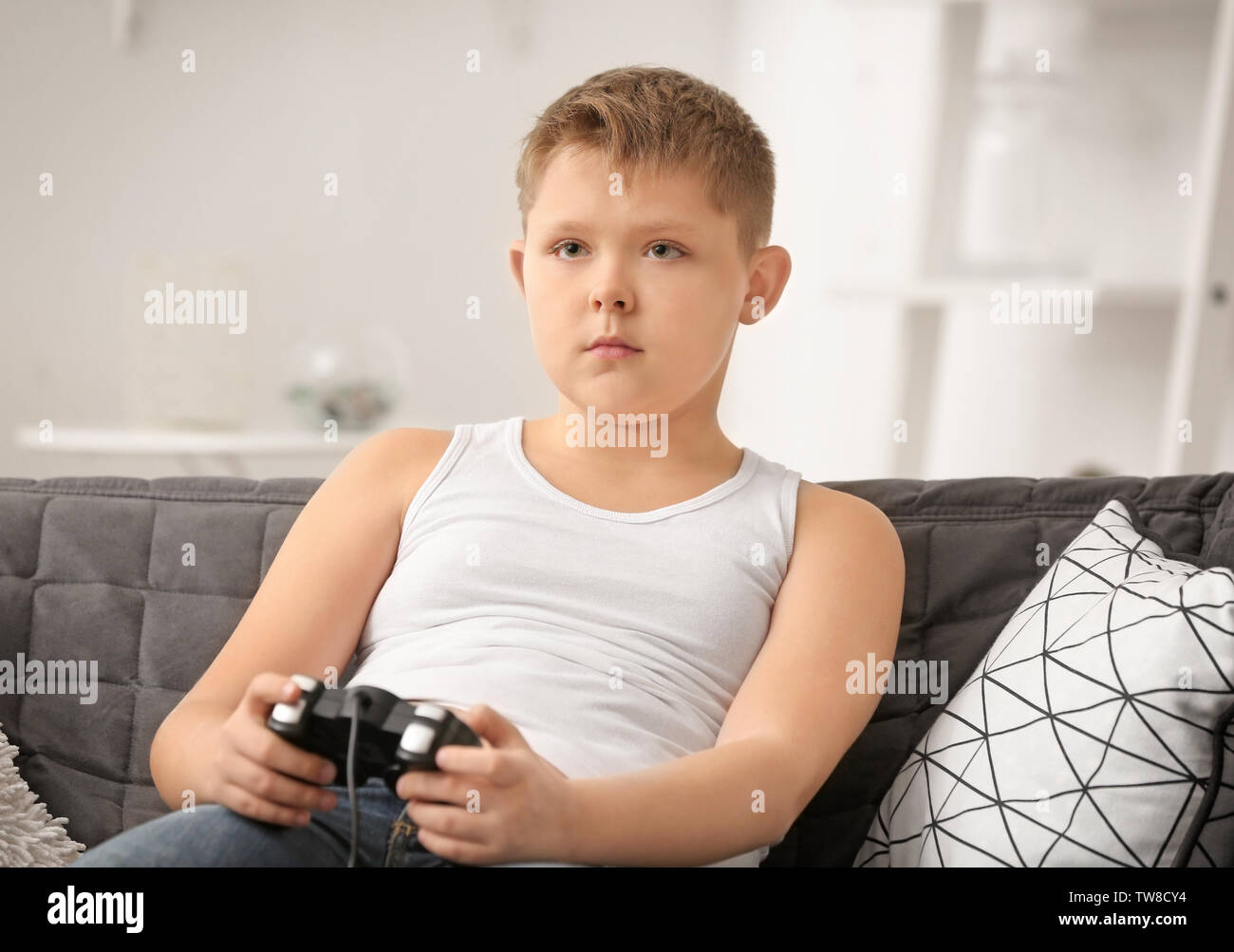 Overweight boy playing video game at home Stock Photo - Alamy