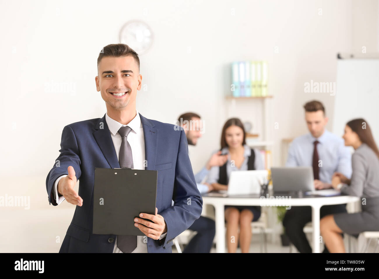 Young businessman offering handshake in conference room Stock Photo - Alamy