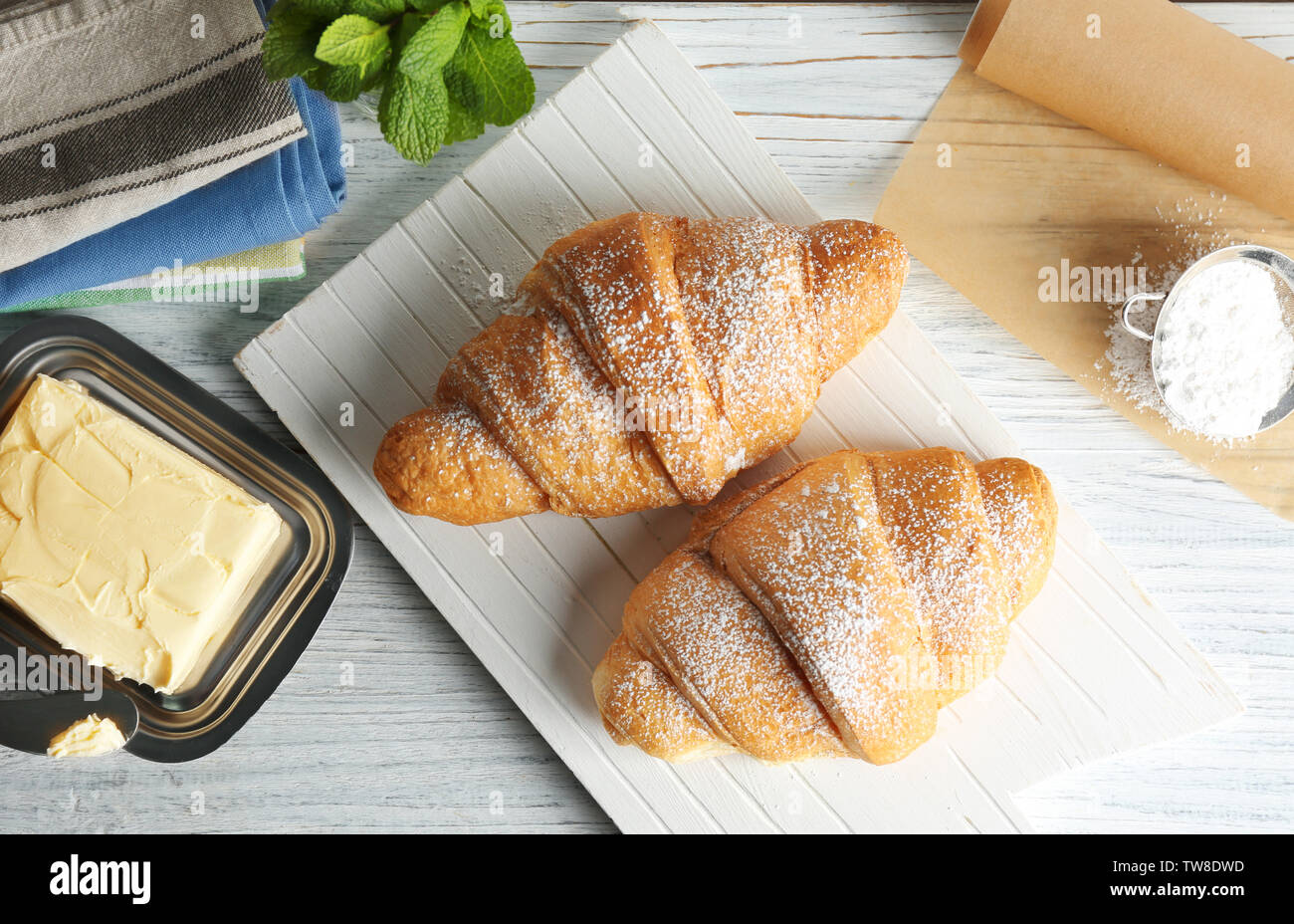 Board with fresh yummy croissants on table Stock Photo - Alamy