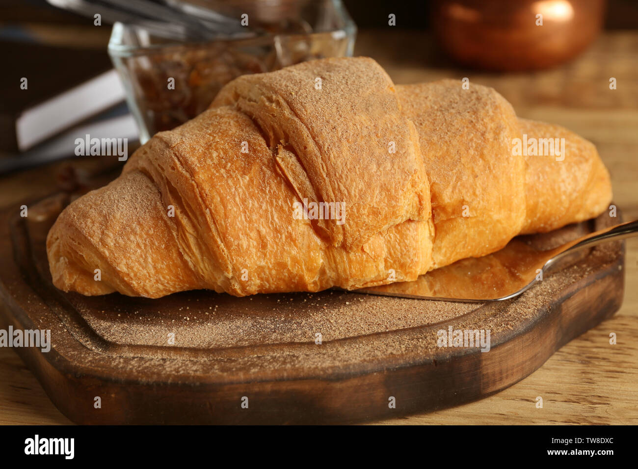 Board with fresh yummy croissant on table Stock Photo - Alamy