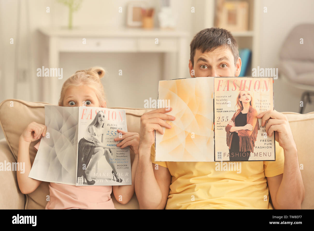 Funny little girl and her father with magazines at home Stock Photo - Alamy