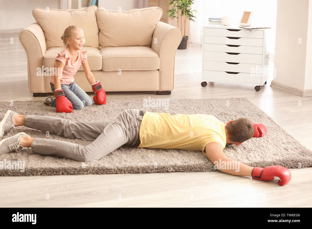 Cute girl and her father in boxing gloves playing at home Stock Photo ...