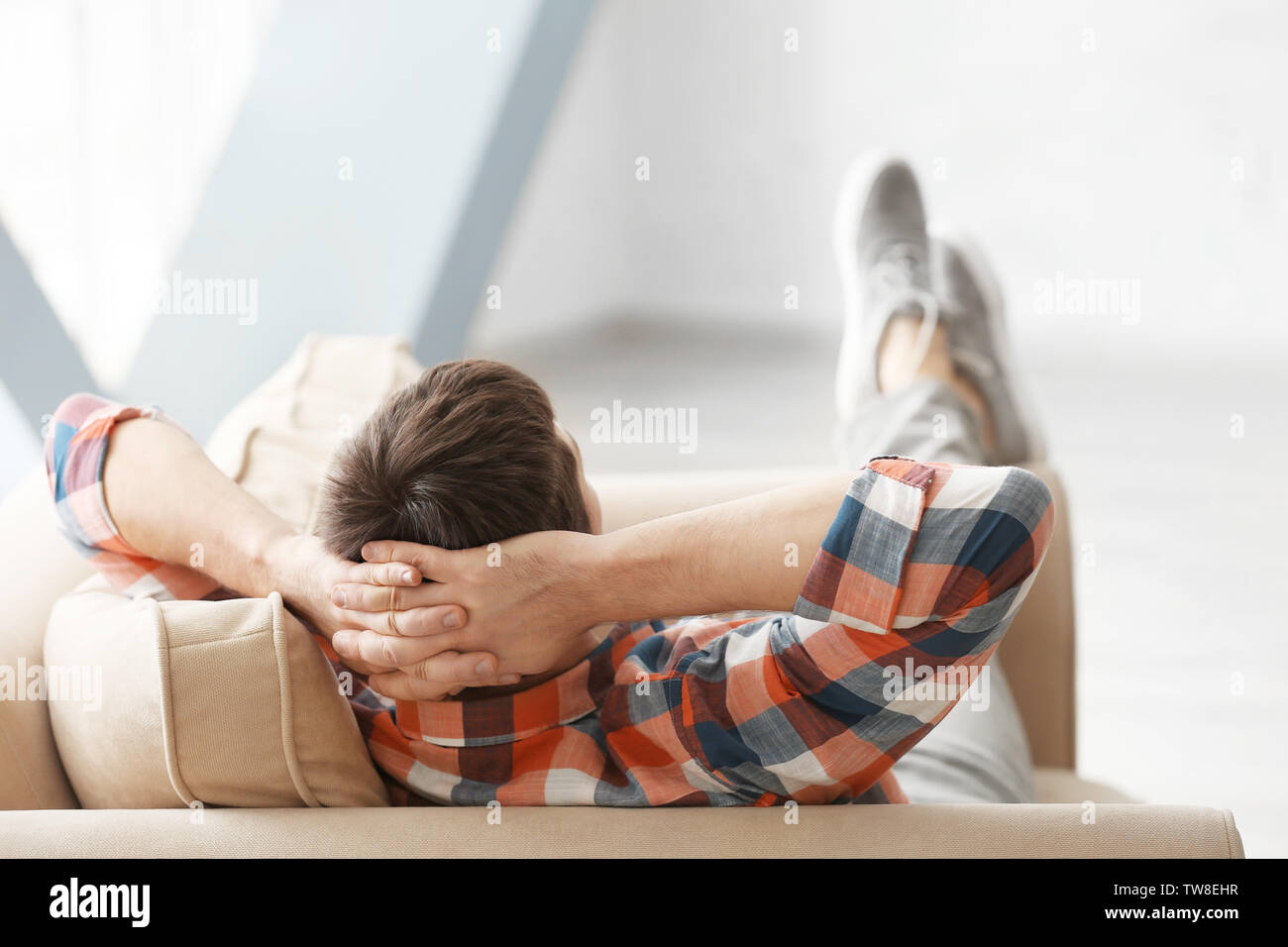 Handsome man relaxing on sofa hi-res stock photography and images - Alamy