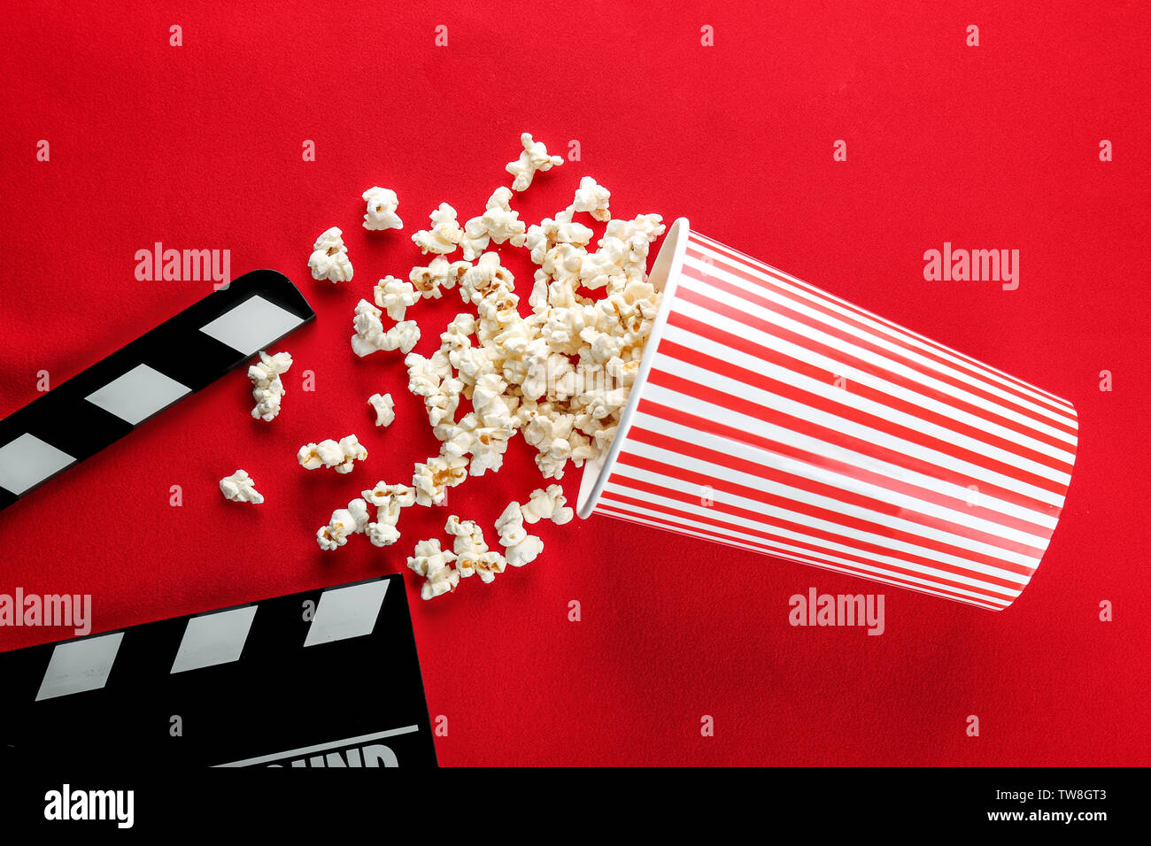 Popcorn and movie clapper on color background Stock Photo - Alamy
