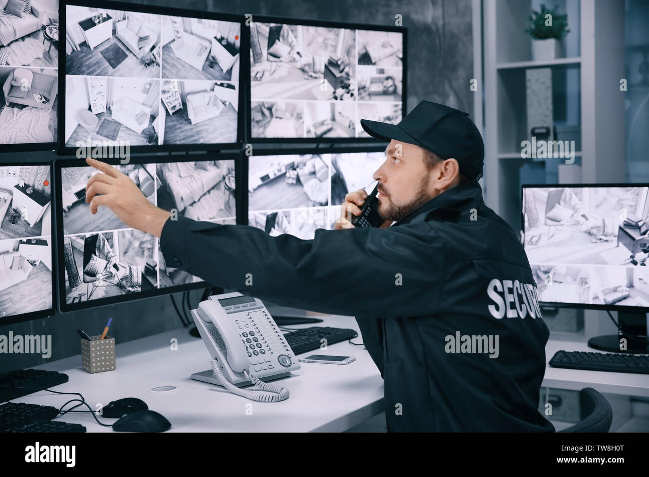 Male security guard using radio transmitter in surveillance room Stock ...