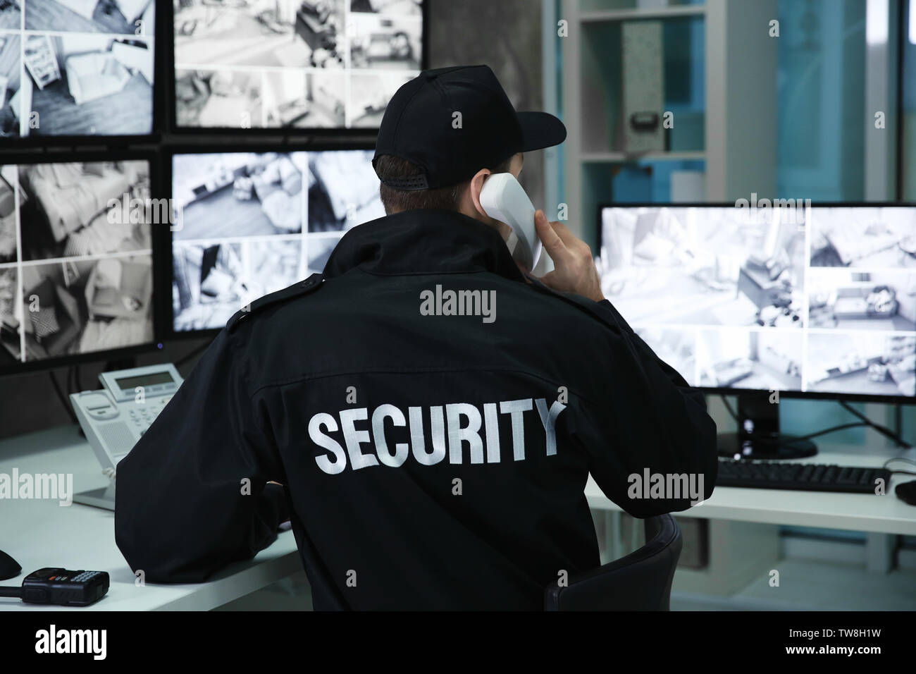 Male security guard talking by telephone in surveillance room Stock ...