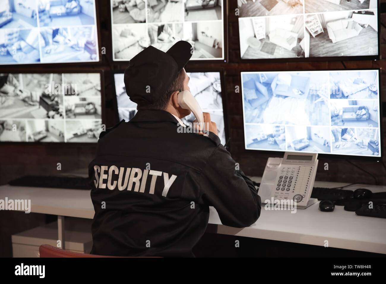 Male security guard talking by telephone in surveillance room Stock ...