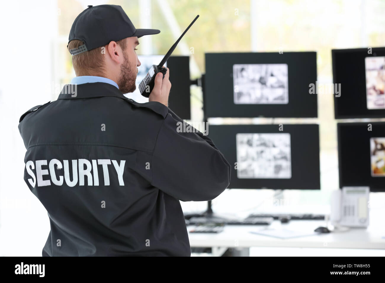 Male security guard using radio transmitter in surveillance room Stock ...