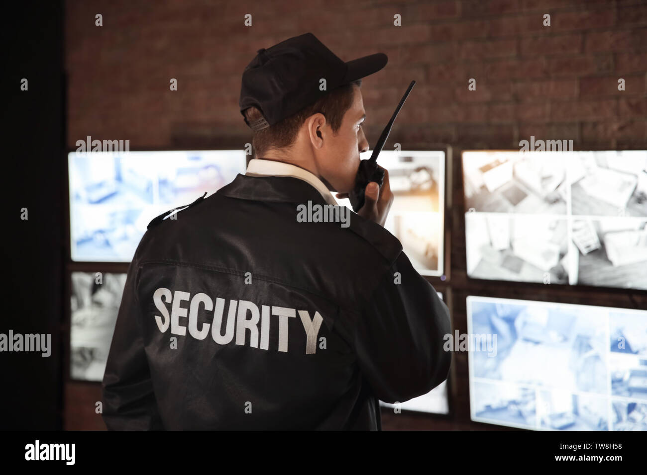 Male security guard using radio transmitter in surveillance room Stock ...