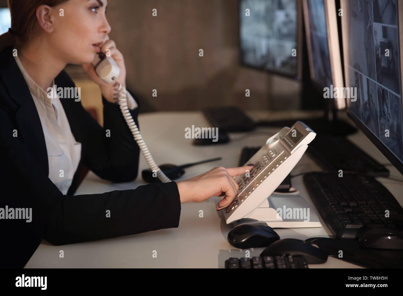 Female security guard talking by telephone in surveillance room Stock ...