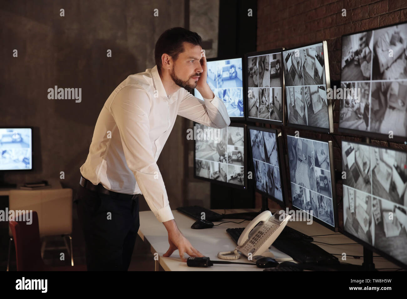 Male security guard working in surveillance room Stock Photo - Alamy