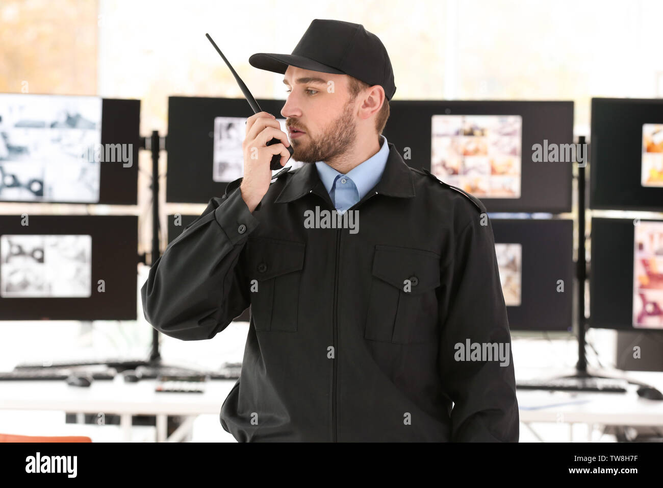 Male security guard using radio transmitter in surveillance room Stock ...