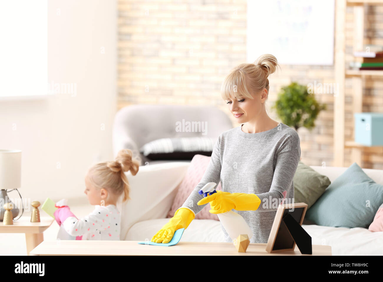 Little girl and her mother cleaning up at home Stock Photo - Alamy