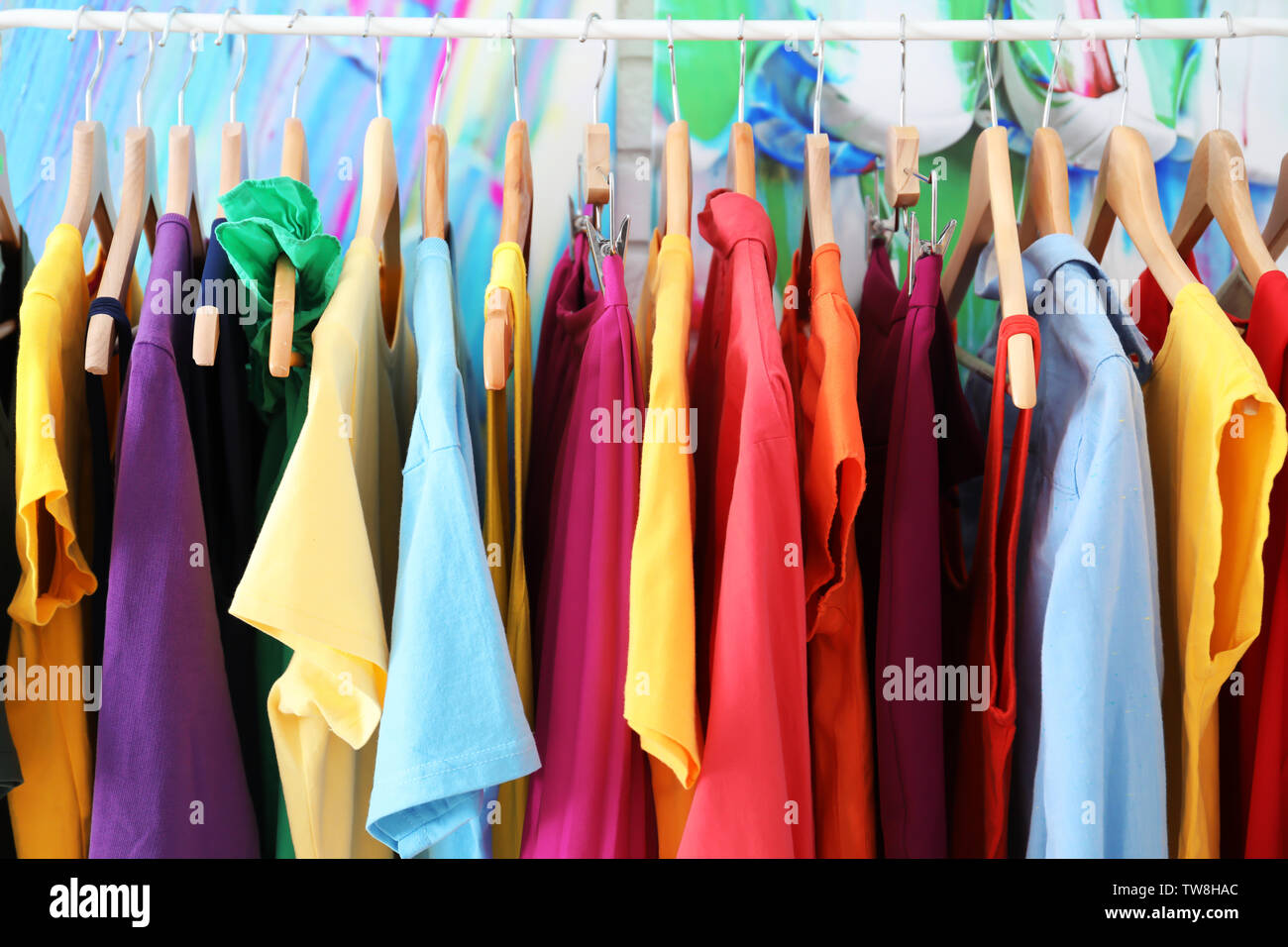 Rainbow clothes hanging on rack Stock Photo - Alamy
