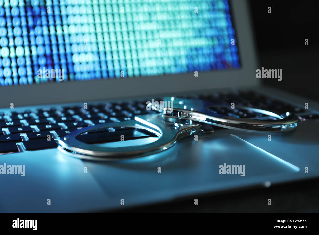 Handcuffs on laptop keyboard, closeup Stock Photo - Alamy