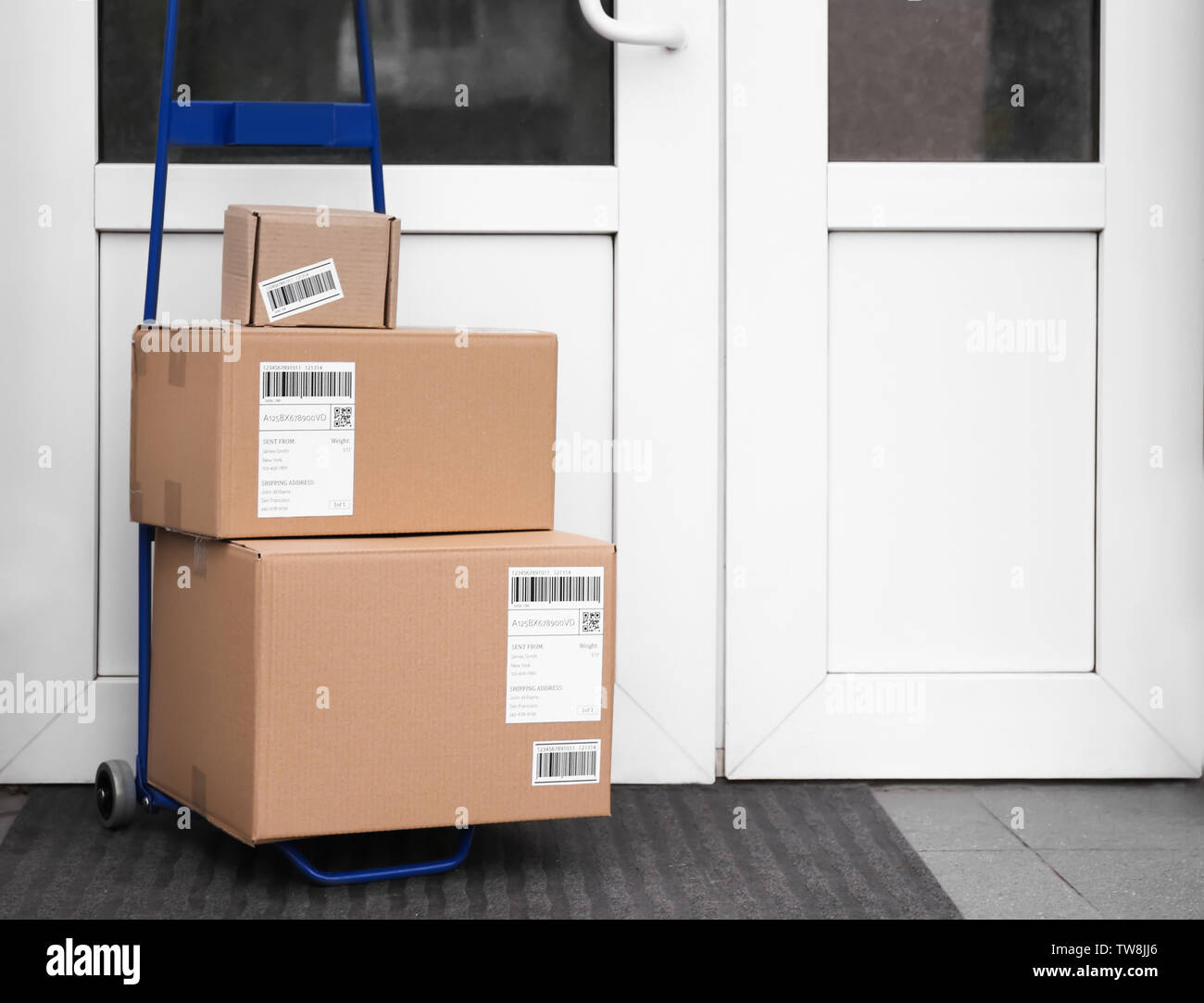 Postal cart with delivered parcels near front door Stock Photo - Alamy