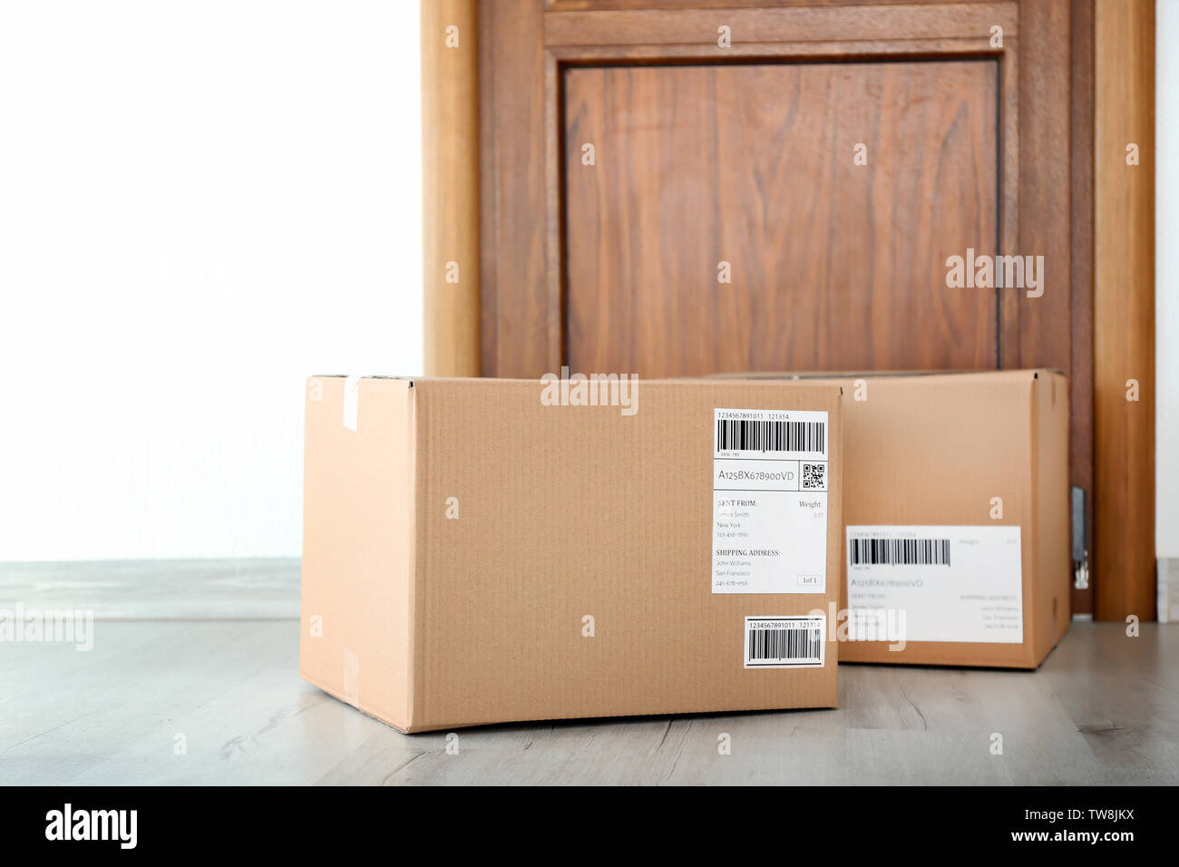 Delivered parcels on floor near front door Stock Photo - Alamy