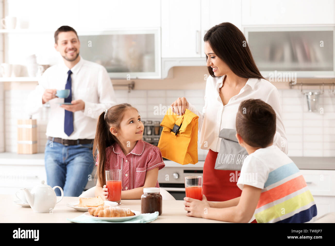 Young mother helping her children get ready for school Stock Photo - Alamy