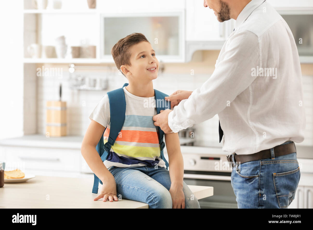 Man helping his son get ready for school Stock Photo - Alamy
