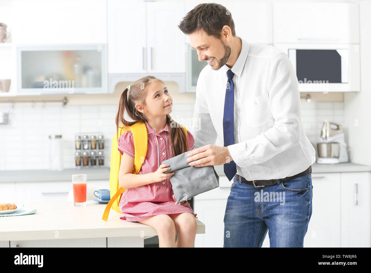 Young man helping his daughter get ready for school Stock Photo - Alamy