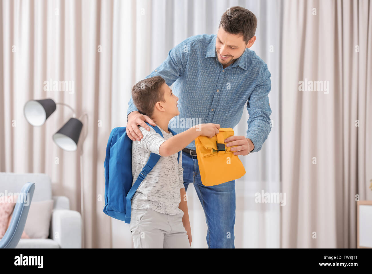 Young man helping his son get ready for school Stock Photo - Alamy